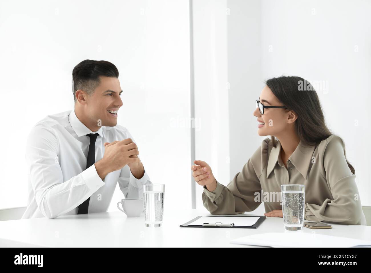 Office employees talking at table during meeting Stock Photo - Alamy