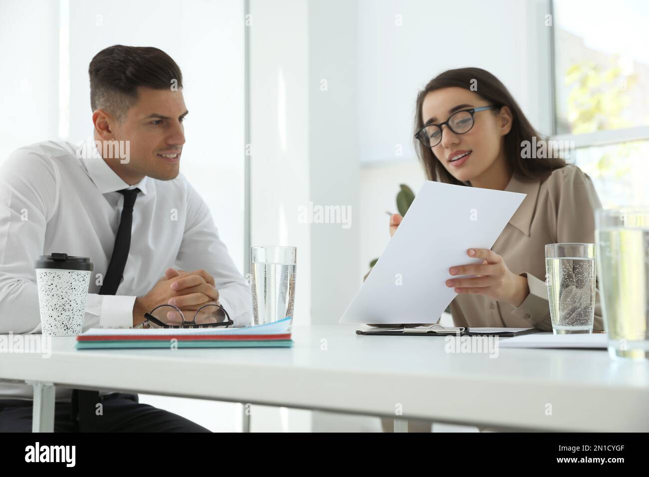 Office employees talking at table during meeting Stock Photo - Alamy