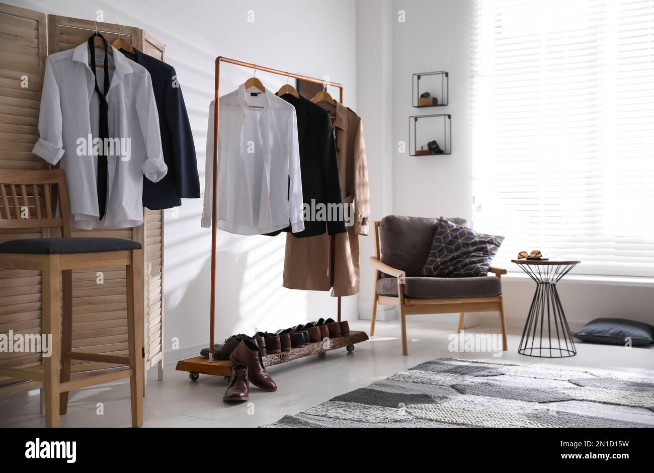 Dressing room interior with clothing rack and armchair Stock Photo - Alamy