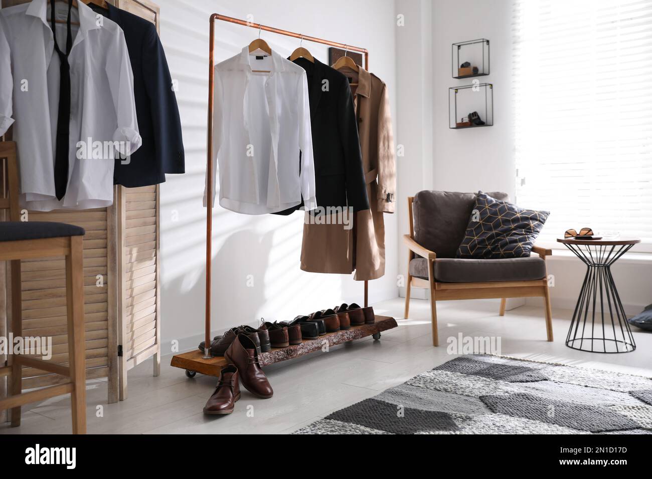 Dressing room interior with clothing rack and armchair Stock Photo - Alamy
