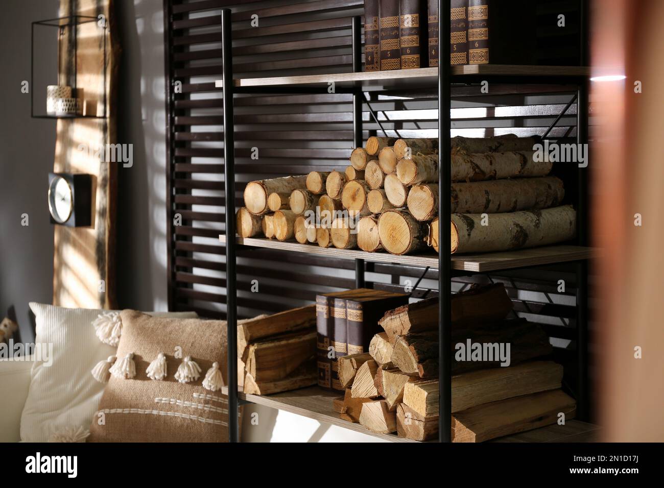 Shelving unit with stacked firewood and books near wall in room. Idea ...