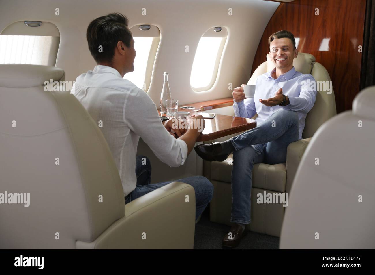 Young men talking during flight. Air travel Stock Photo - Alamy