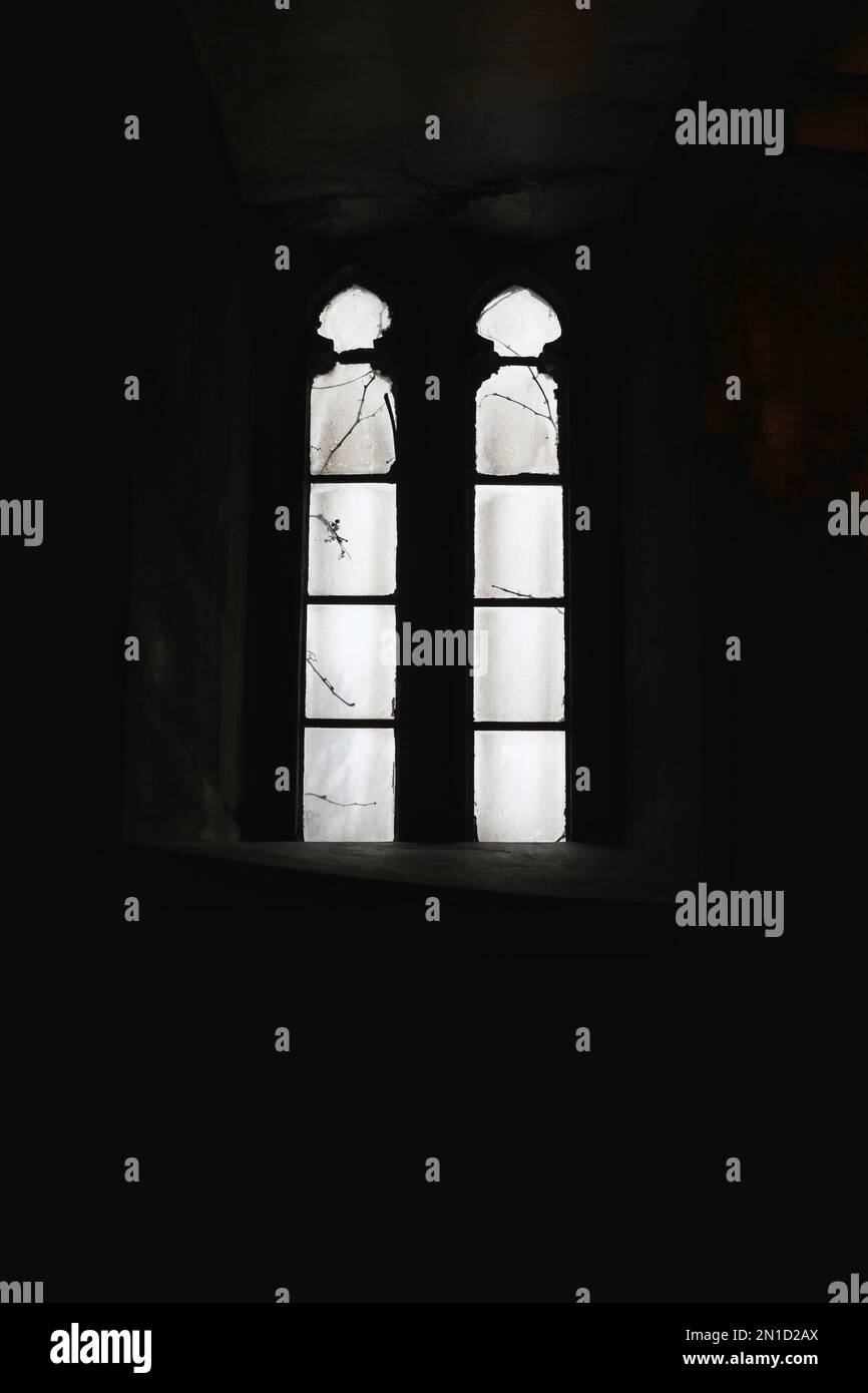 A glowing medieval window on a dark wall Stock Photo - Alamy