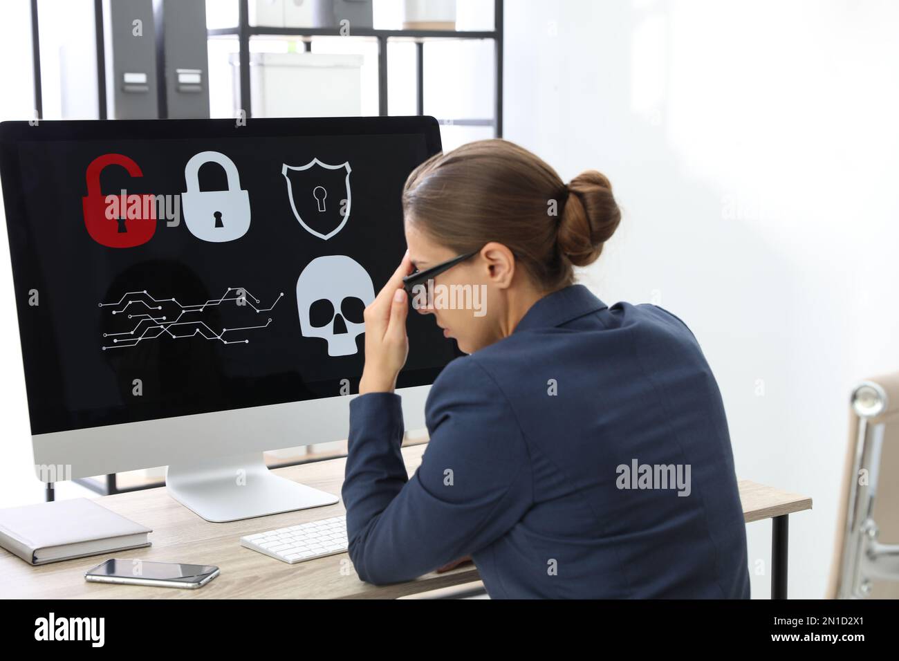 Office worker in front of computer with warning about virus attack on ...