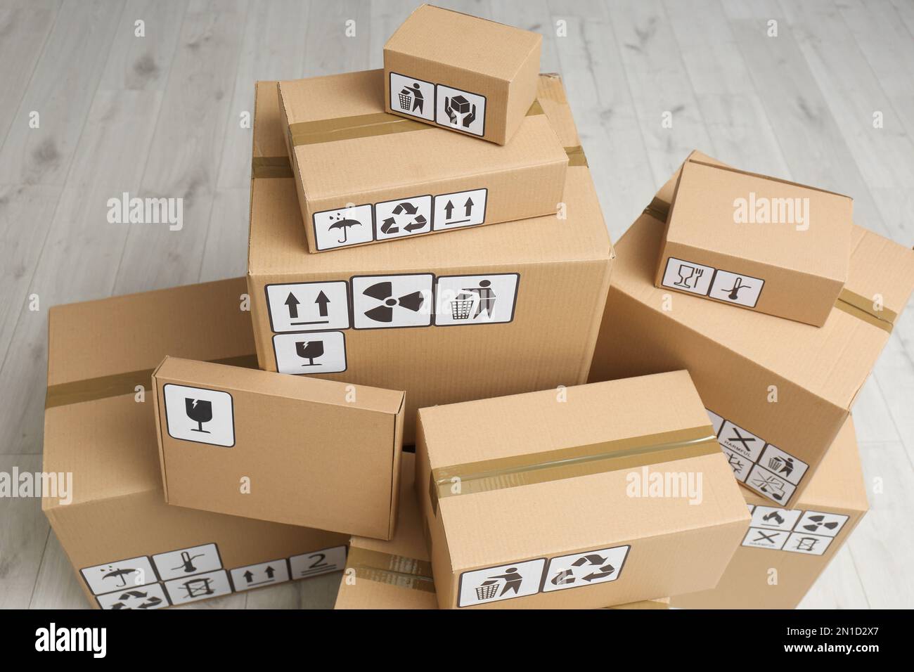 Cardboard boxes with different packaging symbols on floor, above view ...