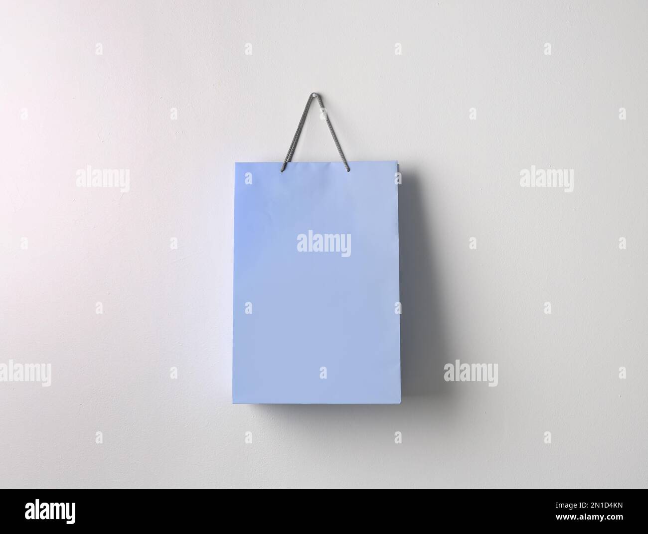 Paper shopping bag hanging on white wall Stock Photo - Alamy