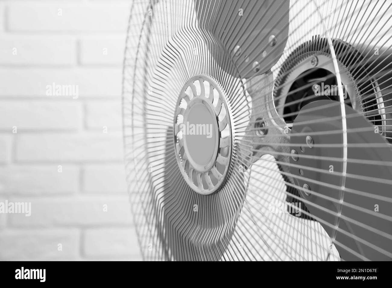 Electric fan near white brick wall, closeup. Summer heat Stock Photo ...