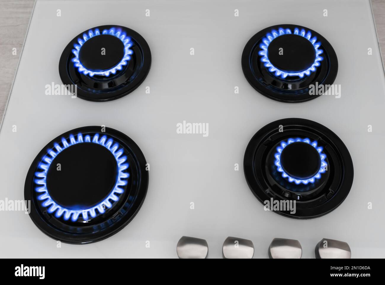 Modern gas cooktop with burning blue flames in kitchen Stock Photo - Alamy