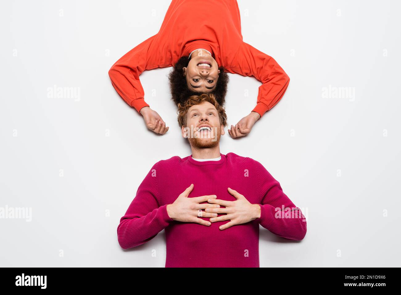 top view of happy redhead man in magenta color clothes and excited ...