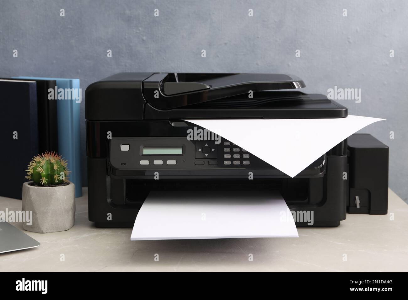 New modern printer on grey table at workplace Stock Photo - Alamy