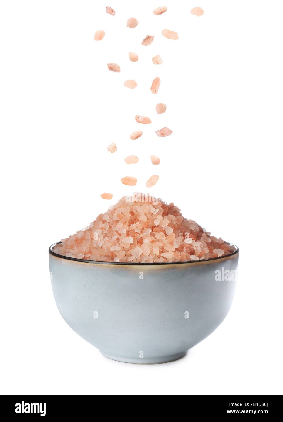 Pink himalayan salt falling into bowl on white background Stock Photo ...