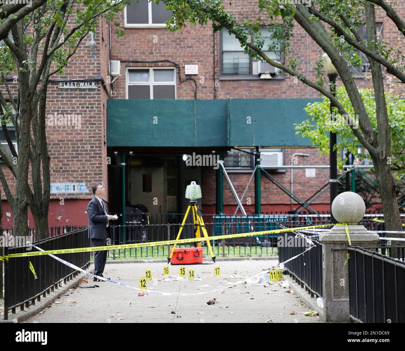 A New York City crime scene investigator inspects the scene of a triple ...