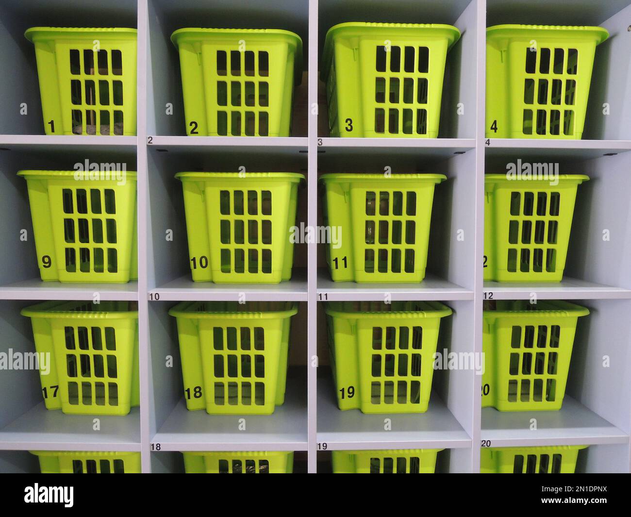 Plastic boxes in numbered wooden cells of shelving in a checkroom Stock ...