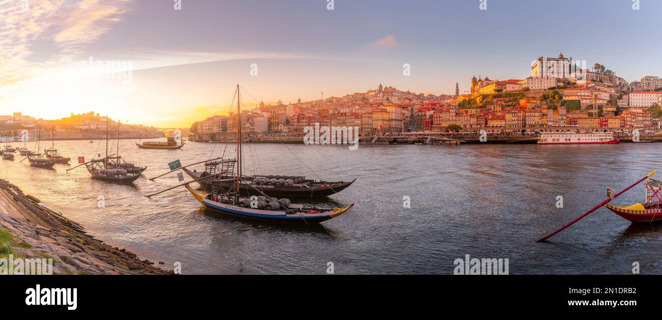 View of Douro River and Rabelo boats aligned with colourful buildings ...