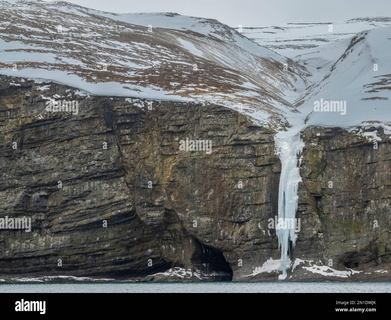 Frozen waterfall at the cliffs at the southern end of the island of ...