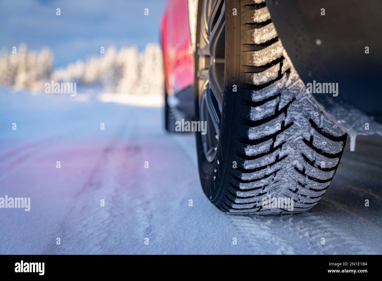 Winter tyre of car driving on slippery road in the snowy forest, Kangos ...
