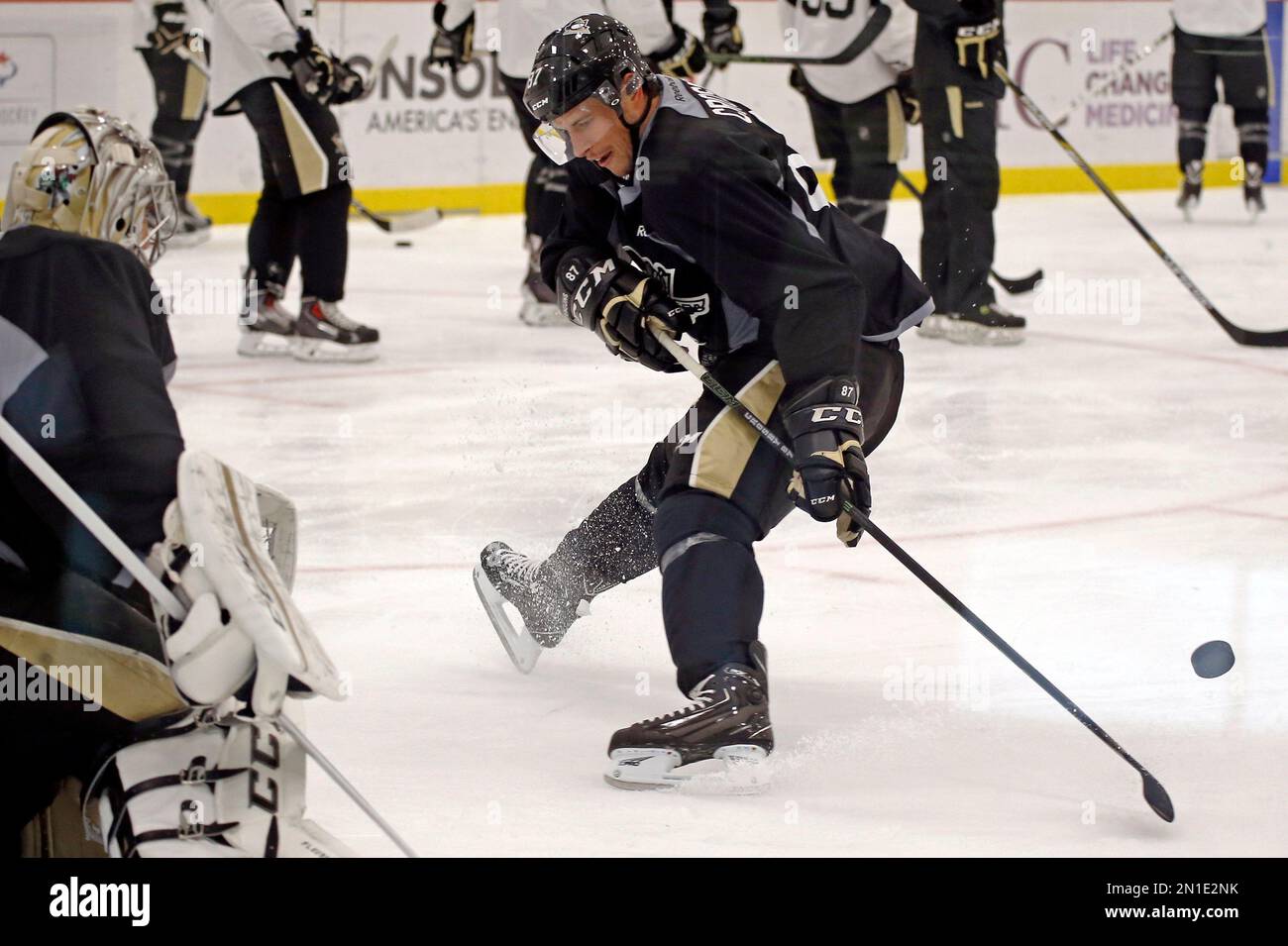 Pittsburgh Penguins' Sidney Crosby, right, reaches back for the puck as ...