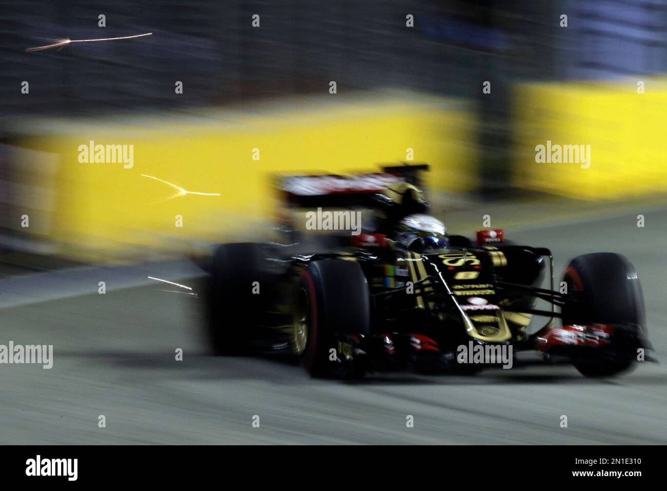 Sparks fly as Lotus driver Romain Grosjean, of France, steers his car ...