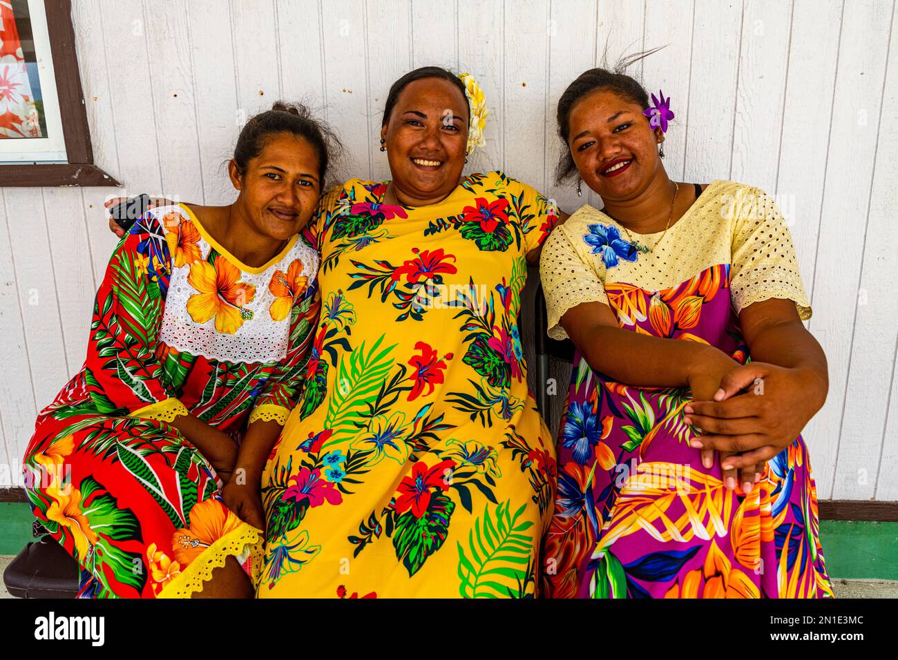 Colourful dressed women with flowers in their hair, Hikueru, Tuamotu ...