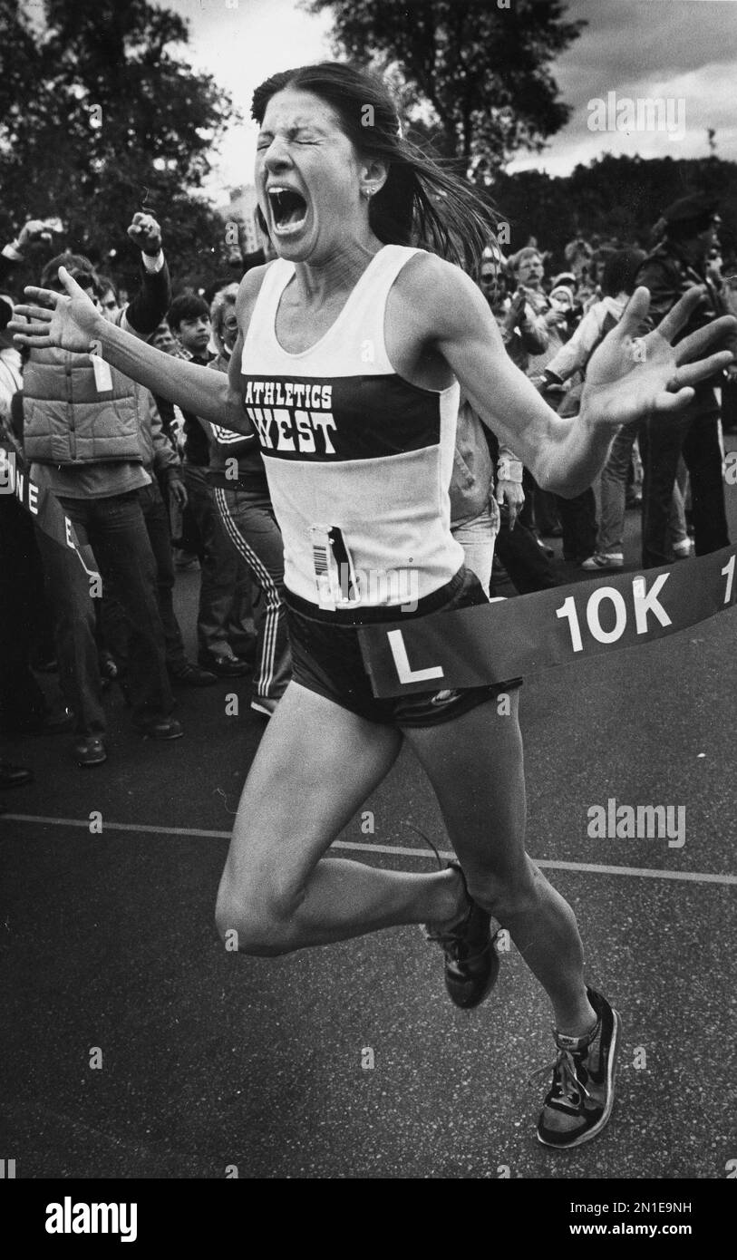 Patti Catalano of West Roxbury, Mass., reacts as she crosses the finish ...