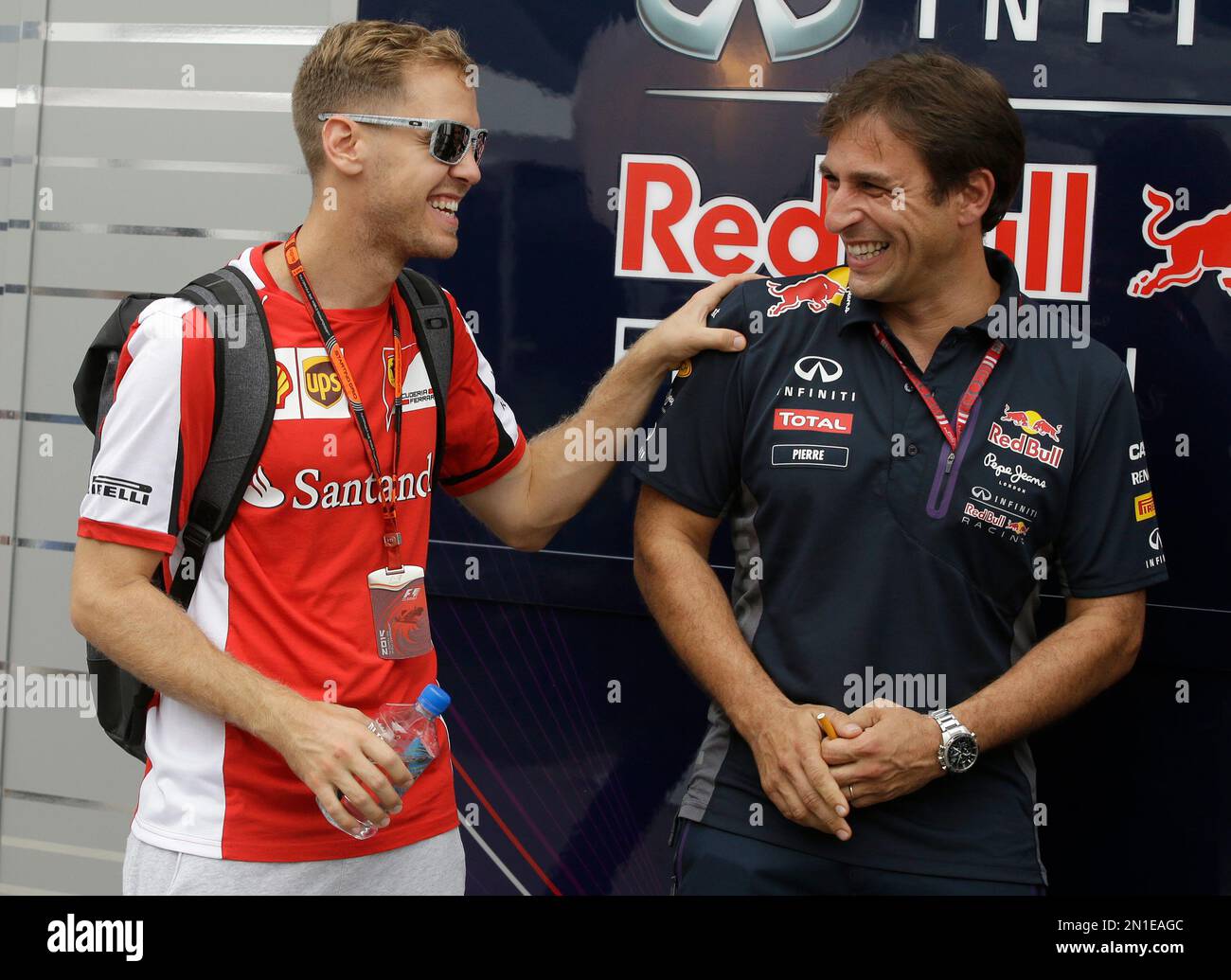 Ferrari driver Sebastian Vettel, left, of Germany jokes with a former ...