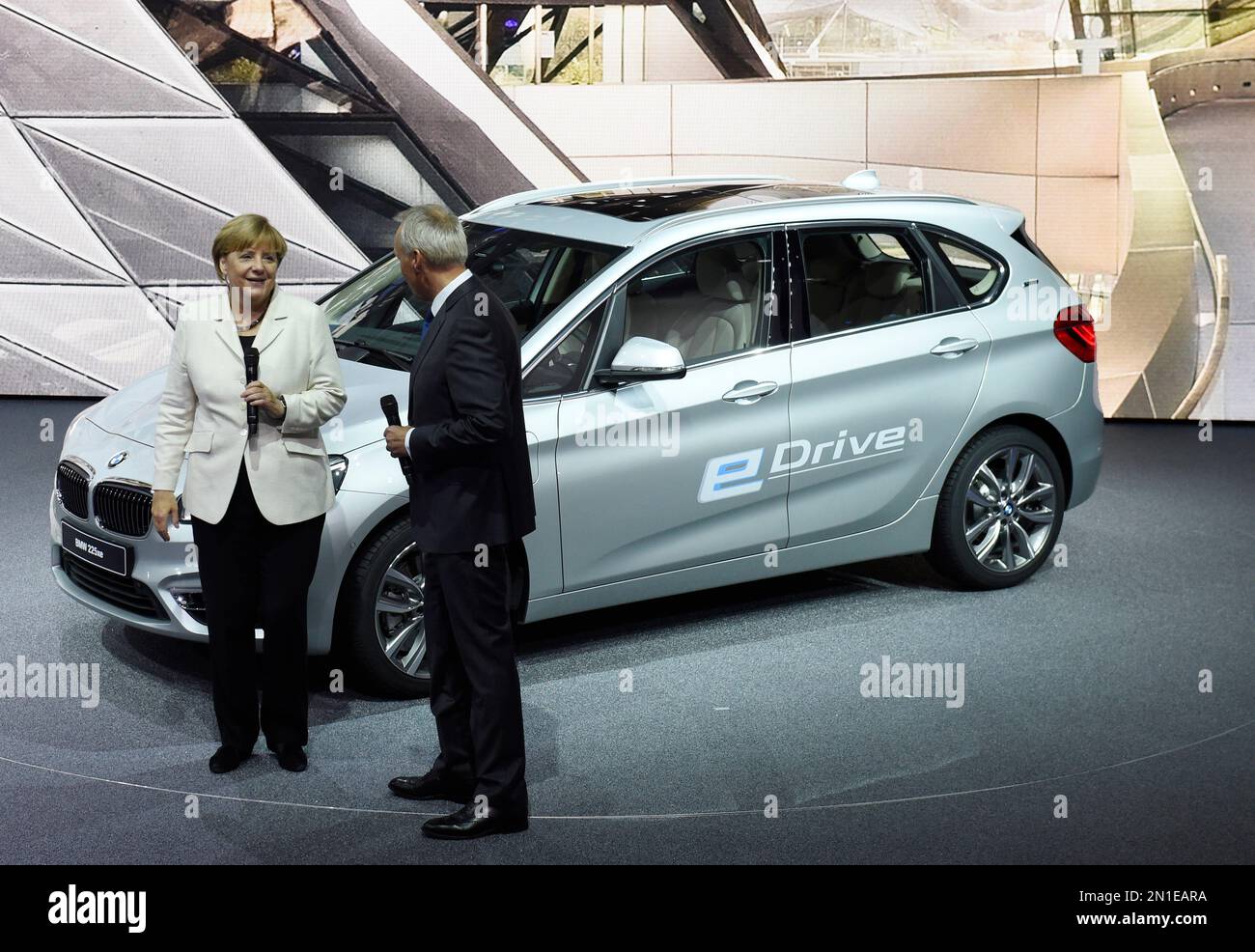 German Chancellor Angela Merkel stands in front of a BMW 225xe on the ...