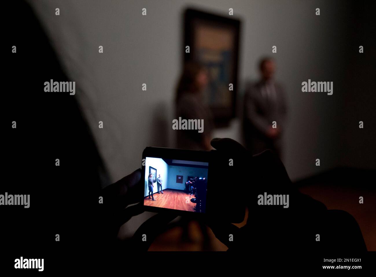A woman takes pictures as museum director Axel Ruger, rear right, poses ...