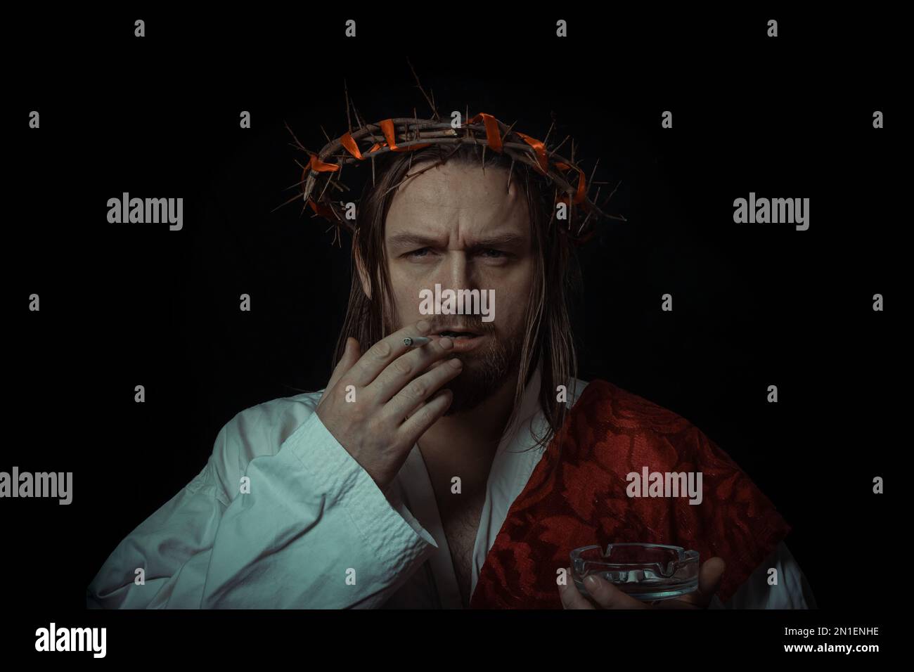 Jesus Christ smokes a cigarette wearing a crown of thorns and white ...