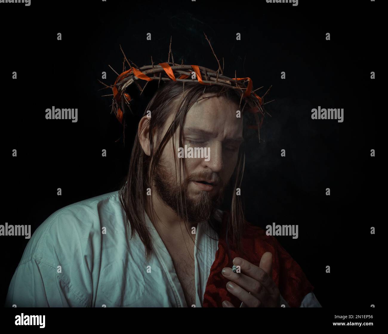 Jesus Christ smokes a cigarette wearing a crown of thorns and white ...
