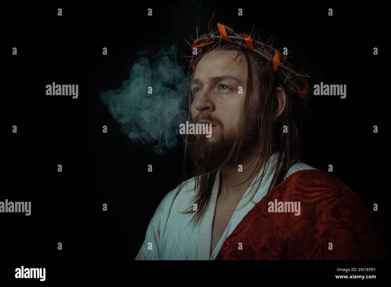 Jesus Christ smokes a cigarette wearing a crown of thorns and white ...