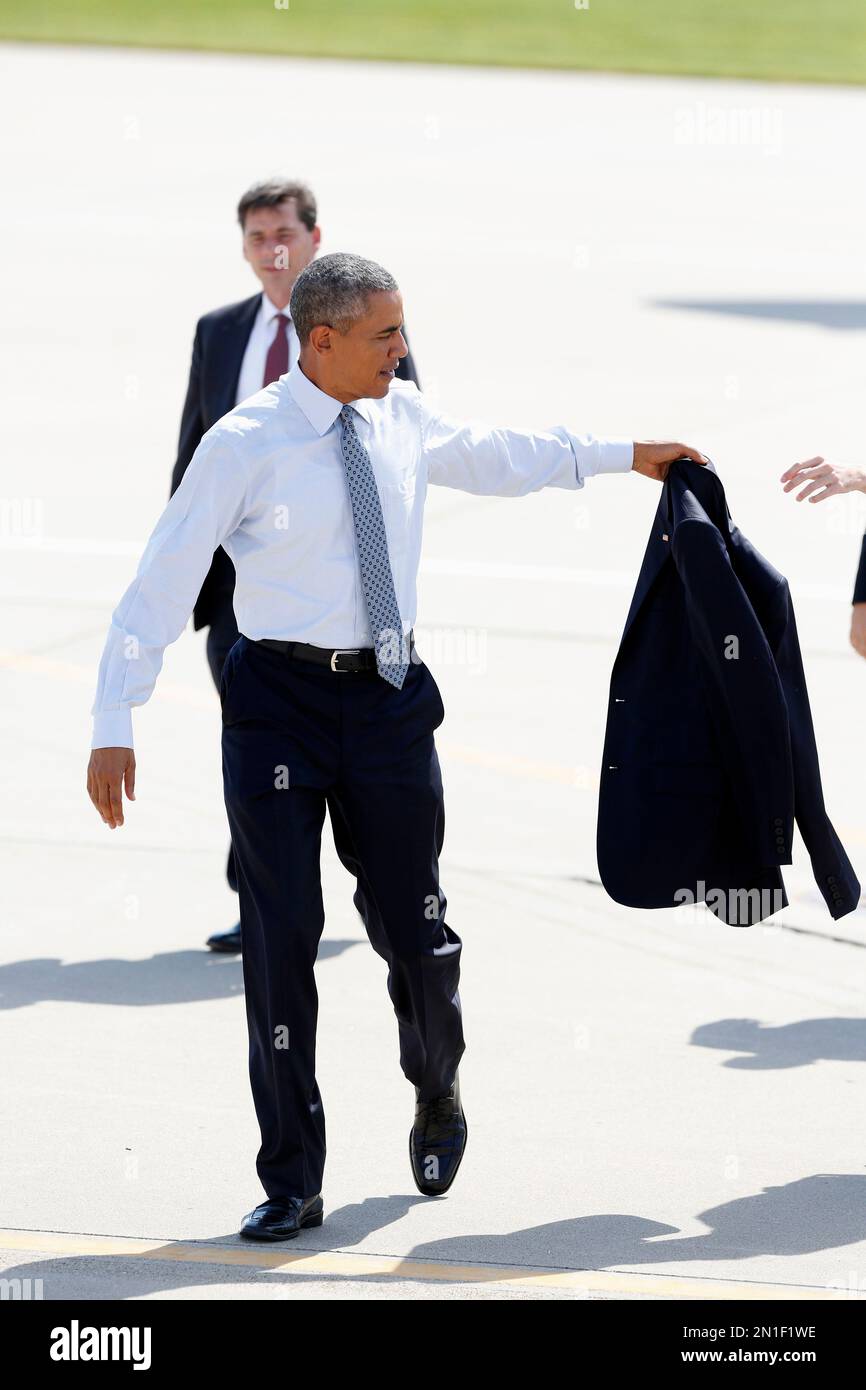 President Barack Obama hands of his coat as he walks to great people on ...