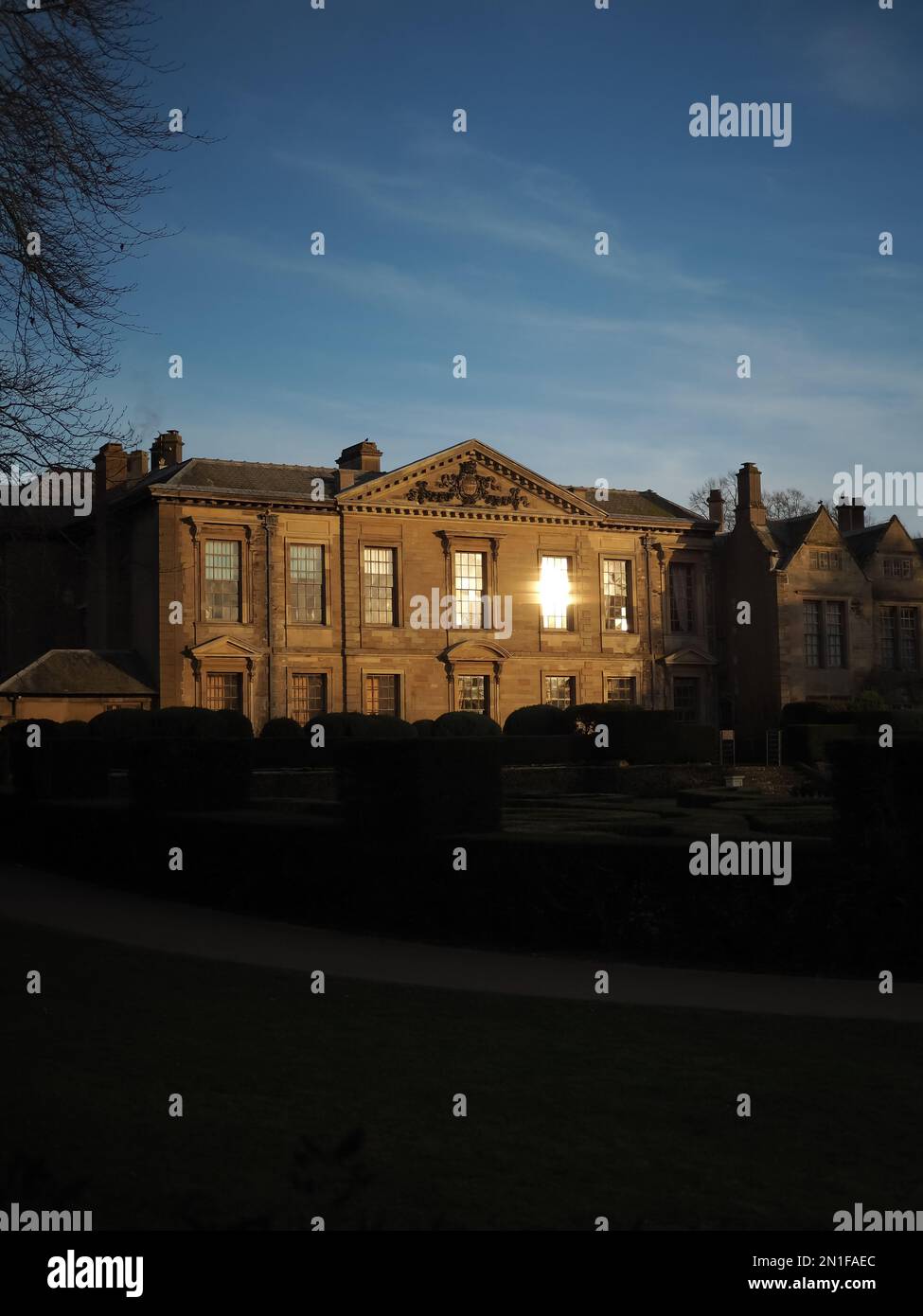 Late afternoon low winter sunlight shining on the exterior of historic ...