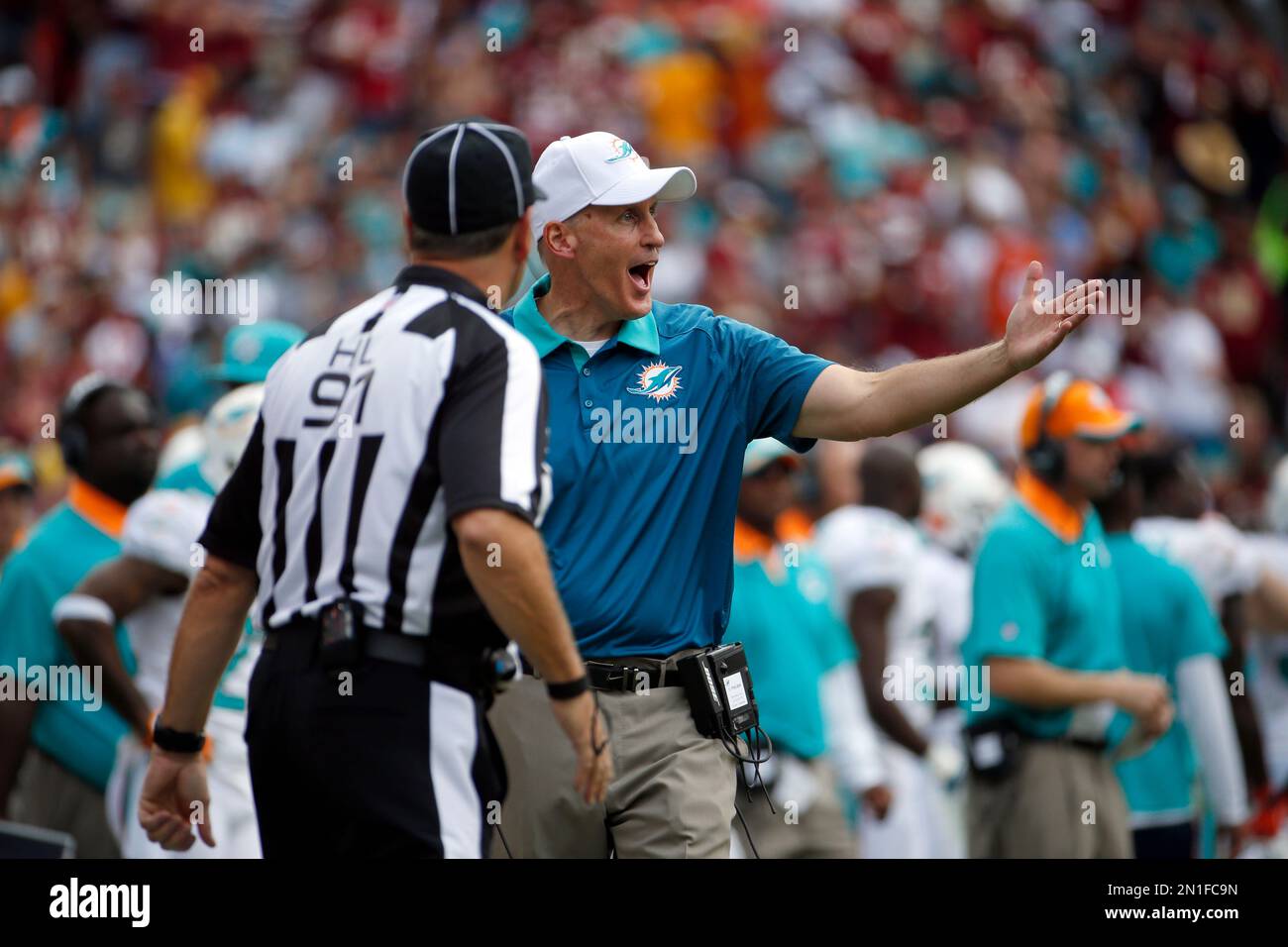 Head linesman Jerry Bergman, left, listens to Miami Dolphins head coach ...