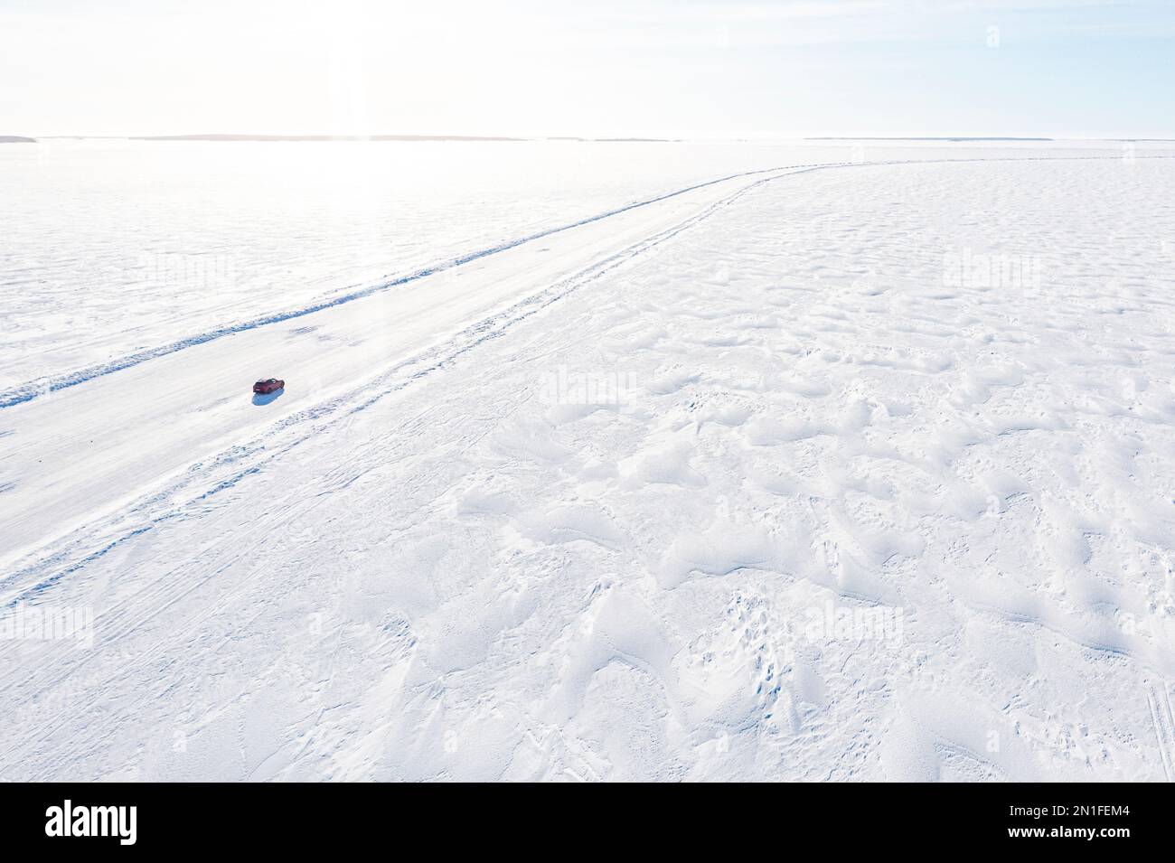 Aerial view of car driving on a slippery ice road on the frozen Arctic ...