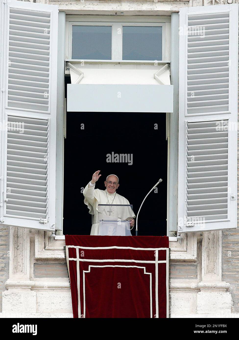 Pope Francis waves to faithful from his studio's window overlooking St ...