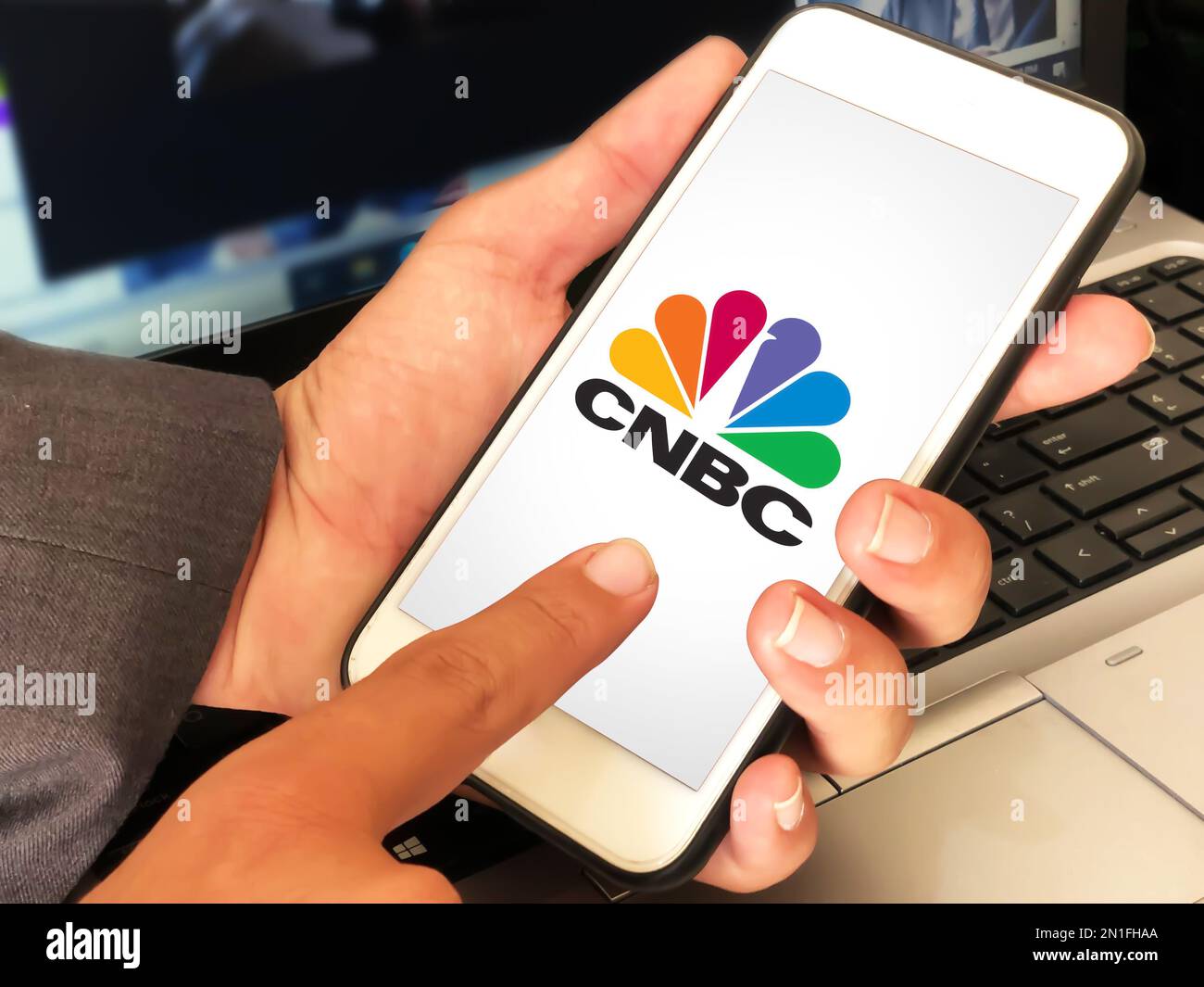 CNBC application is opened on mobile screen with man touching ...
