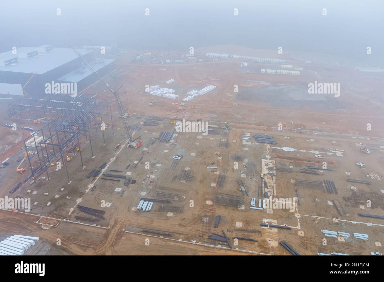 Construction site at dawn at times when heavy fog use tower cranes work ...