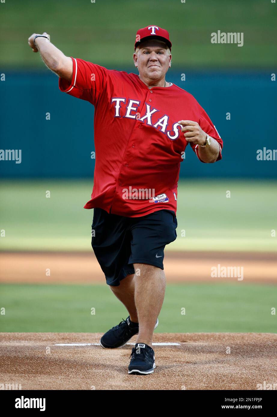 Professional golfer John Daly delivers the ceremonial first pitch ...