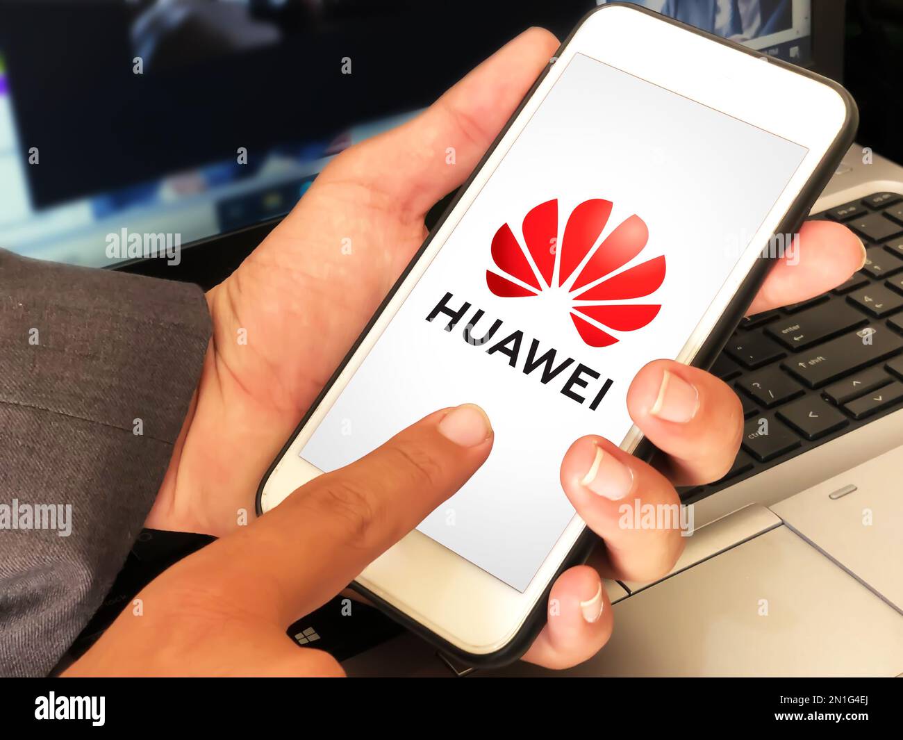 Man using Huawei on mobile screen by touching and laptop in the ...