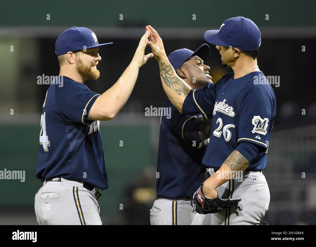 Milwaukee Brewers' Adam Lind, left, high fives pitcher Kyle Lohse, (26 ...