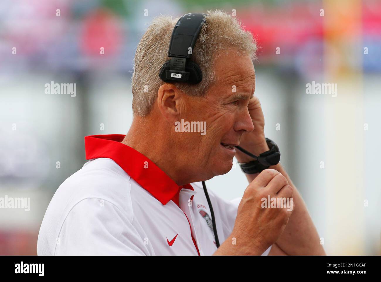 New Mexico head coach Bob Davie speaks with assistants through his ...