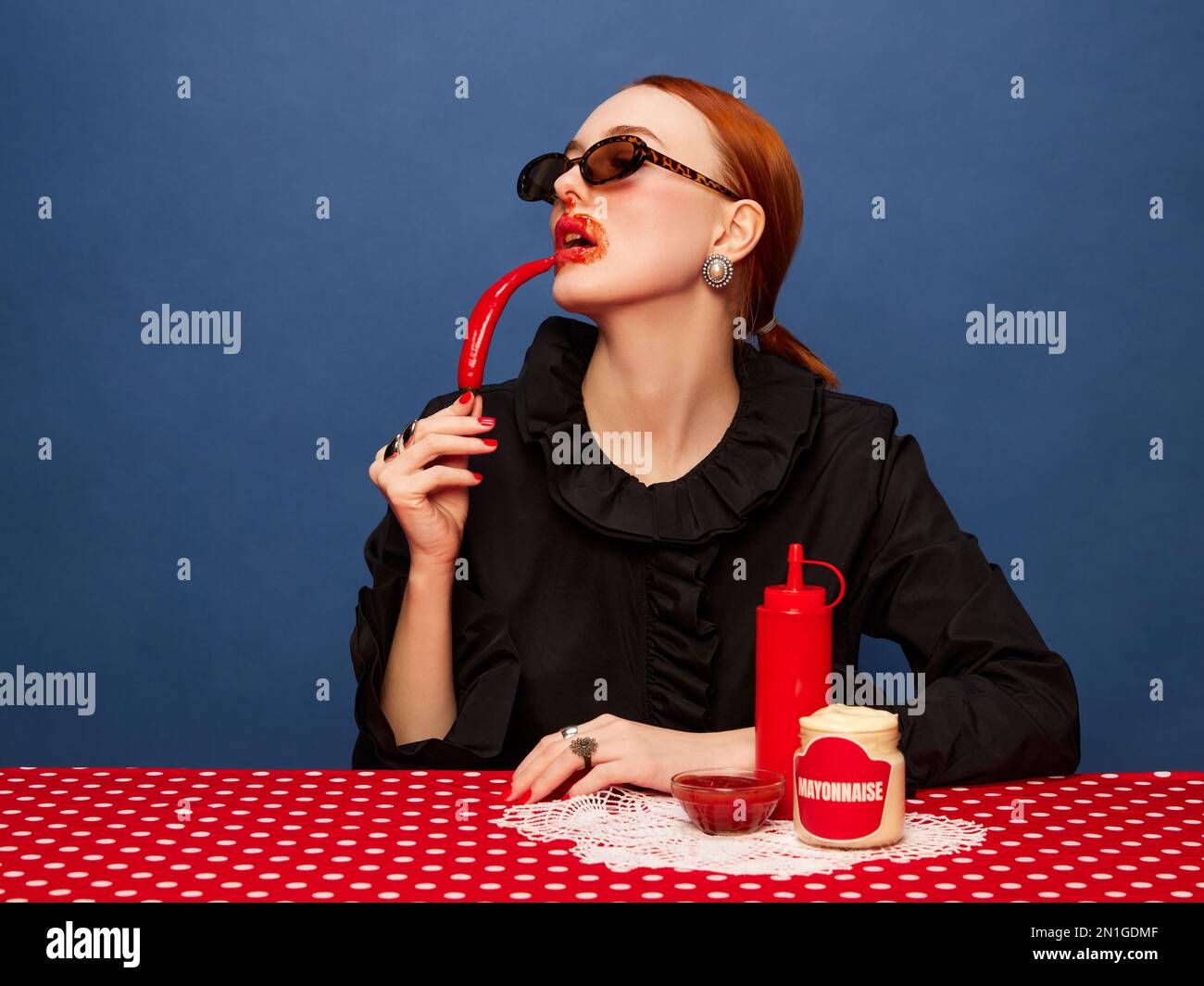 Young beautiful girl eating spicy red chilli pepper, ketchup and ...