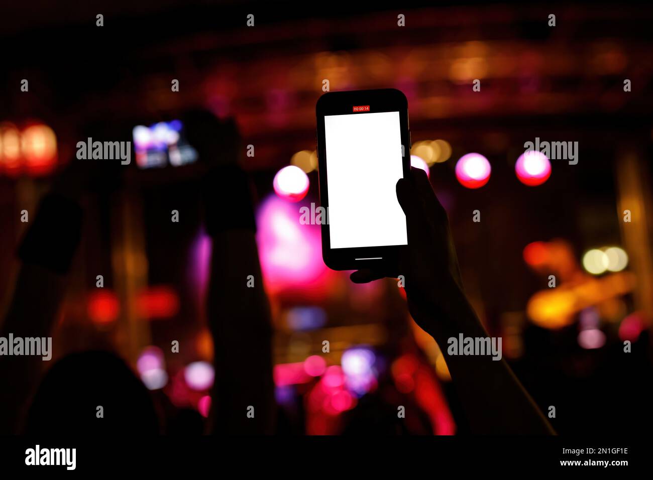 Using a mobile phone at a music concert. Mock-up with a blank screen ...