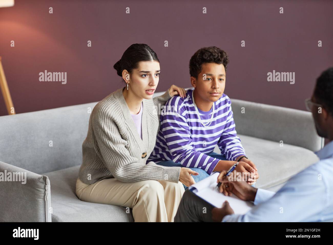 Worried mother and her teenage son visiting psychologist to ask for ...