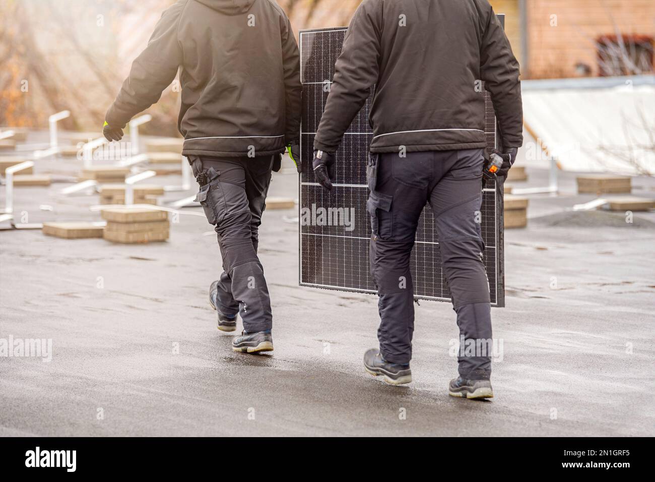 The process of installing solar panels. Solar panel installers work on the roof. Installers ...