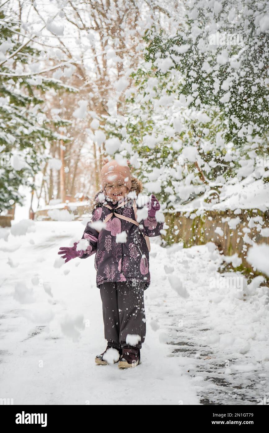 Snow falling and little girl, slow motion. Happy child rejoices in ...