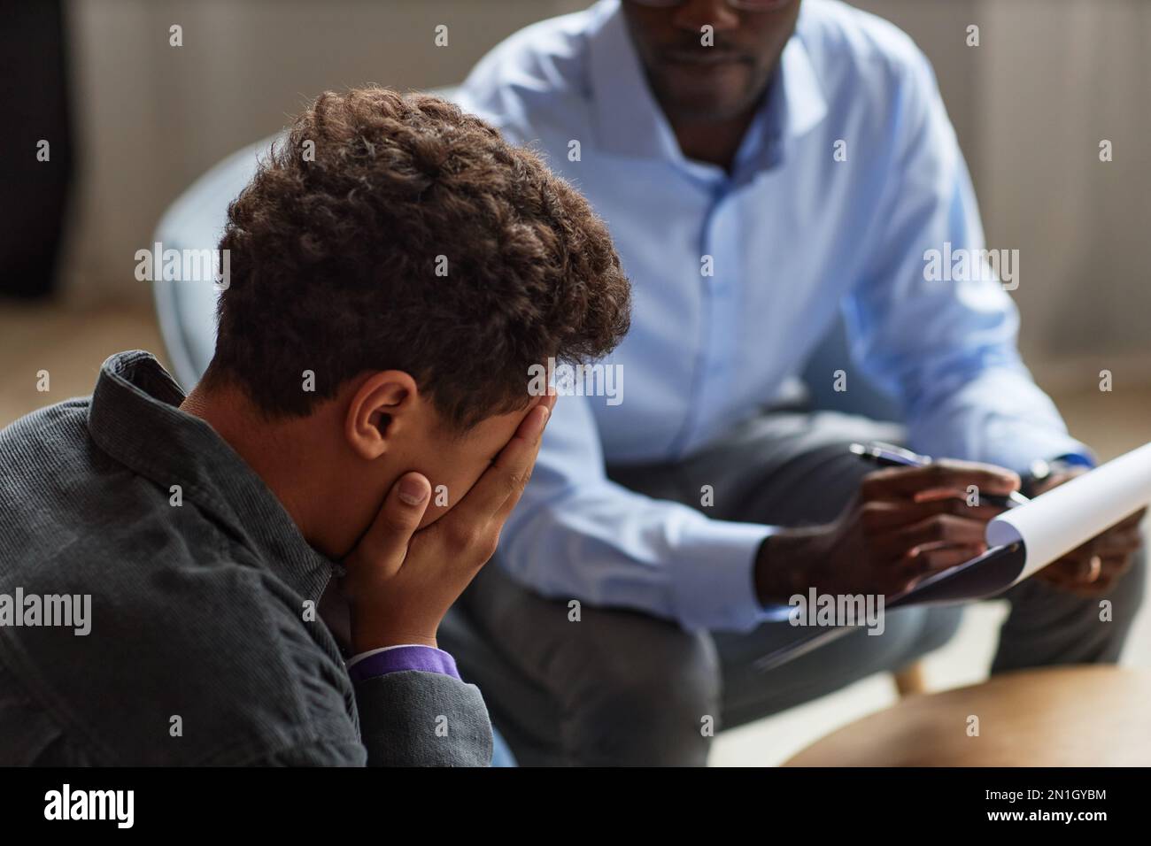 Teenage boy crying when talking to school psychologist about bullying ...
