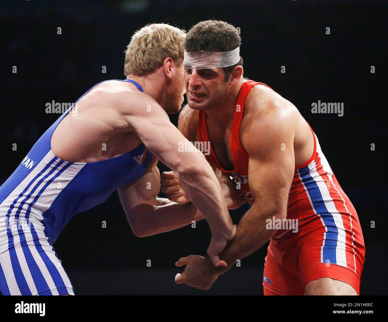 Artur Aleksanyan, of Armenia, in blue, wrestles with Ghasem Gholamreza ...
