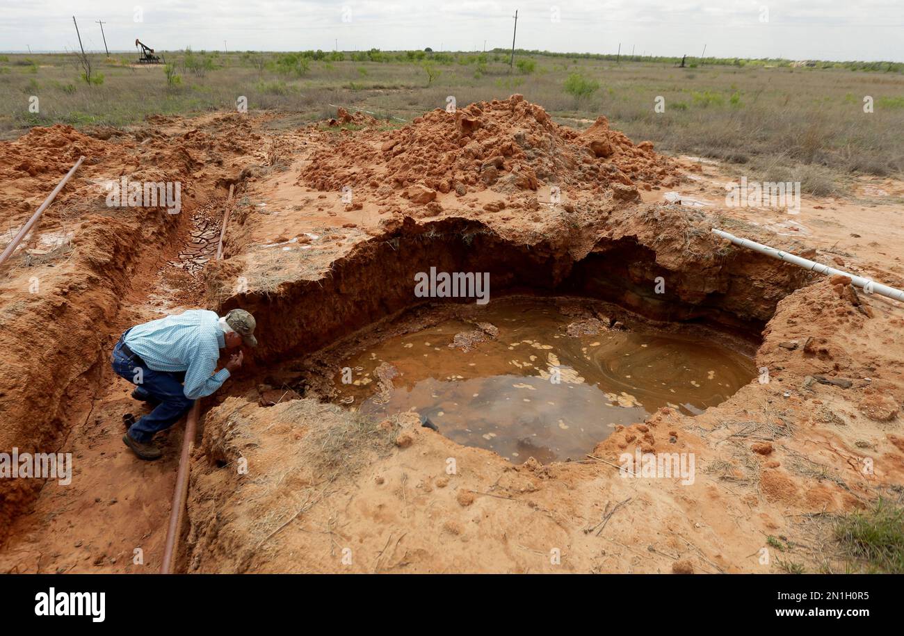 In this April 22, 2015 photo, Wesley Graves looks over a crater left ...