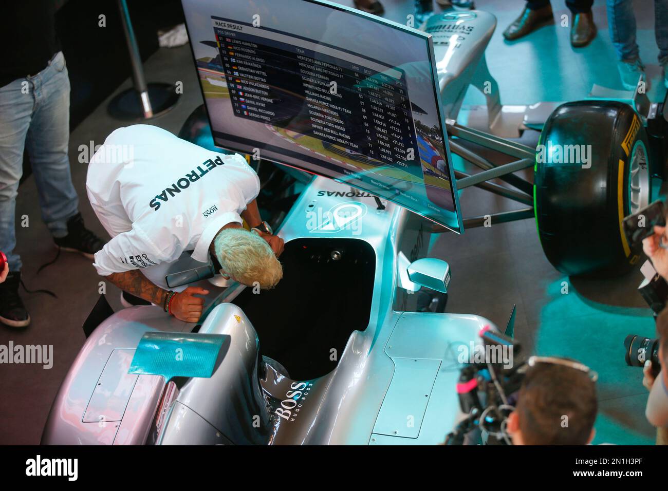 Mercedes F1 British driver Lewis Hamilton looks into the cockpit of his ...